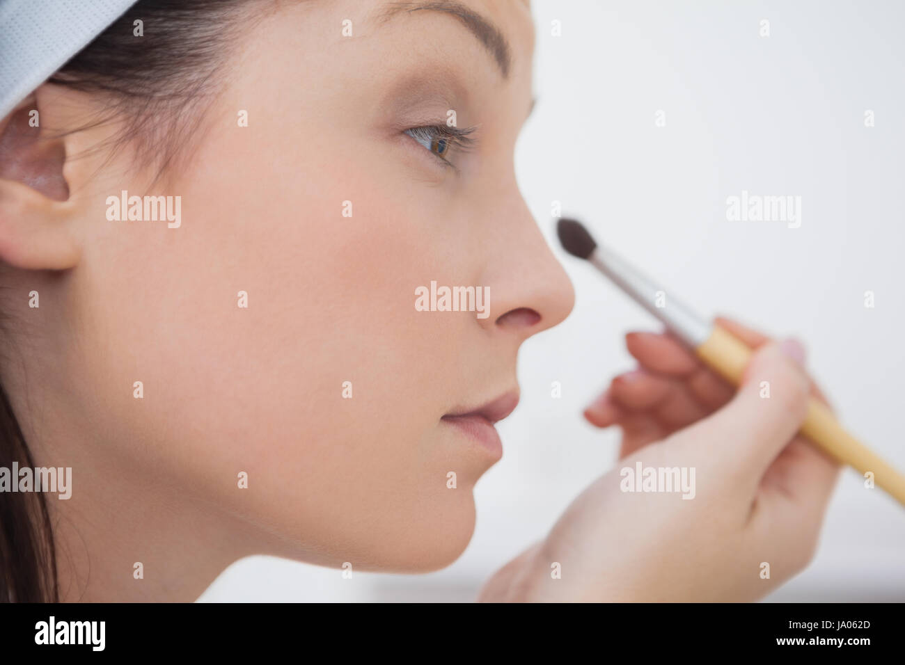 Closeup side view of young woman putting on makeup Stock Photo - Alamy
