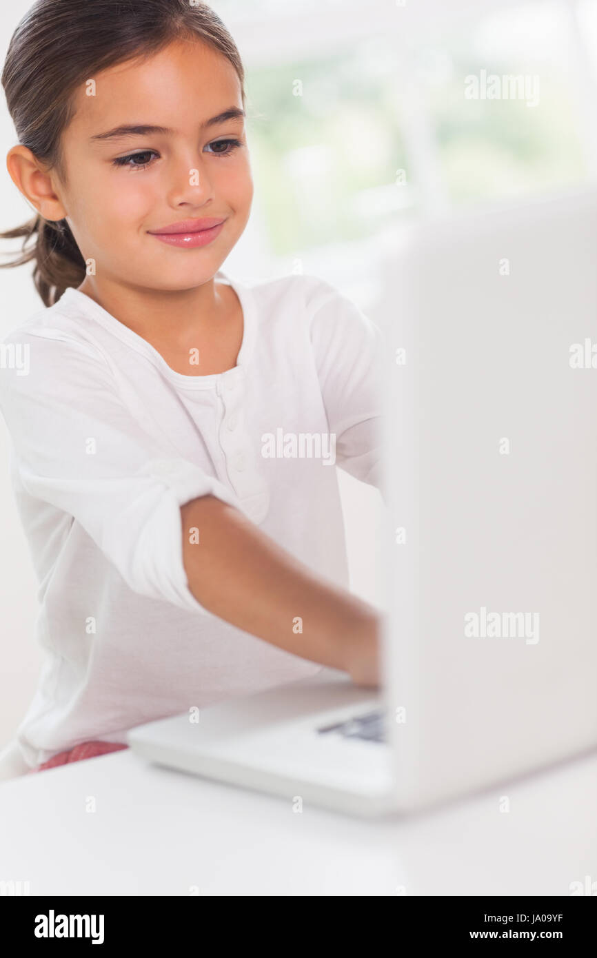 Child using white laptop in kitchen Stock Photo - Alamy