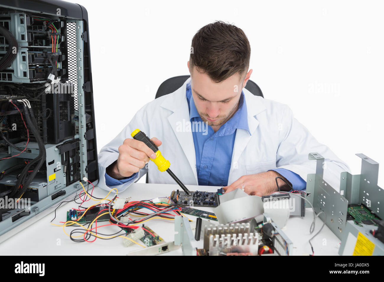Young computer engineer working on cpu parts over white background ...