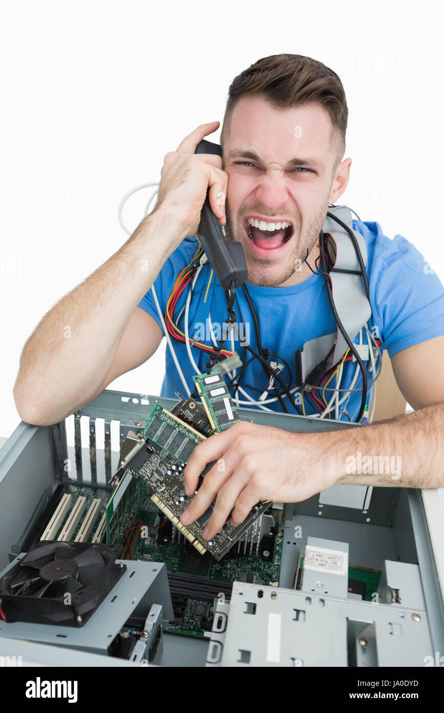 Portrait of frustrated computer engineer screaming over the phone in ...