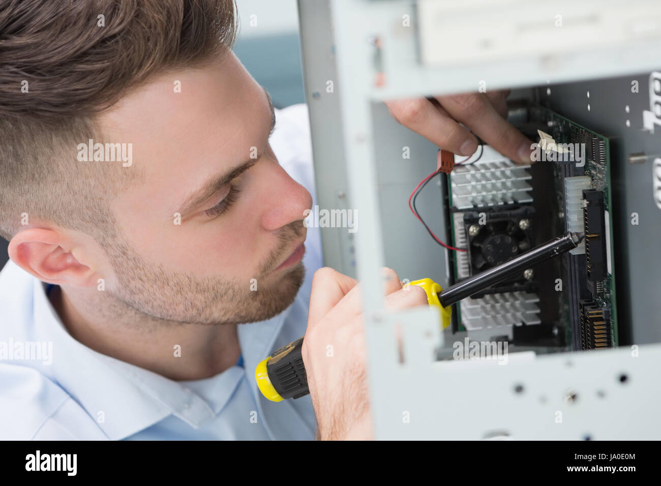 Closeup of young it professional fixing computer problem at workplace ...