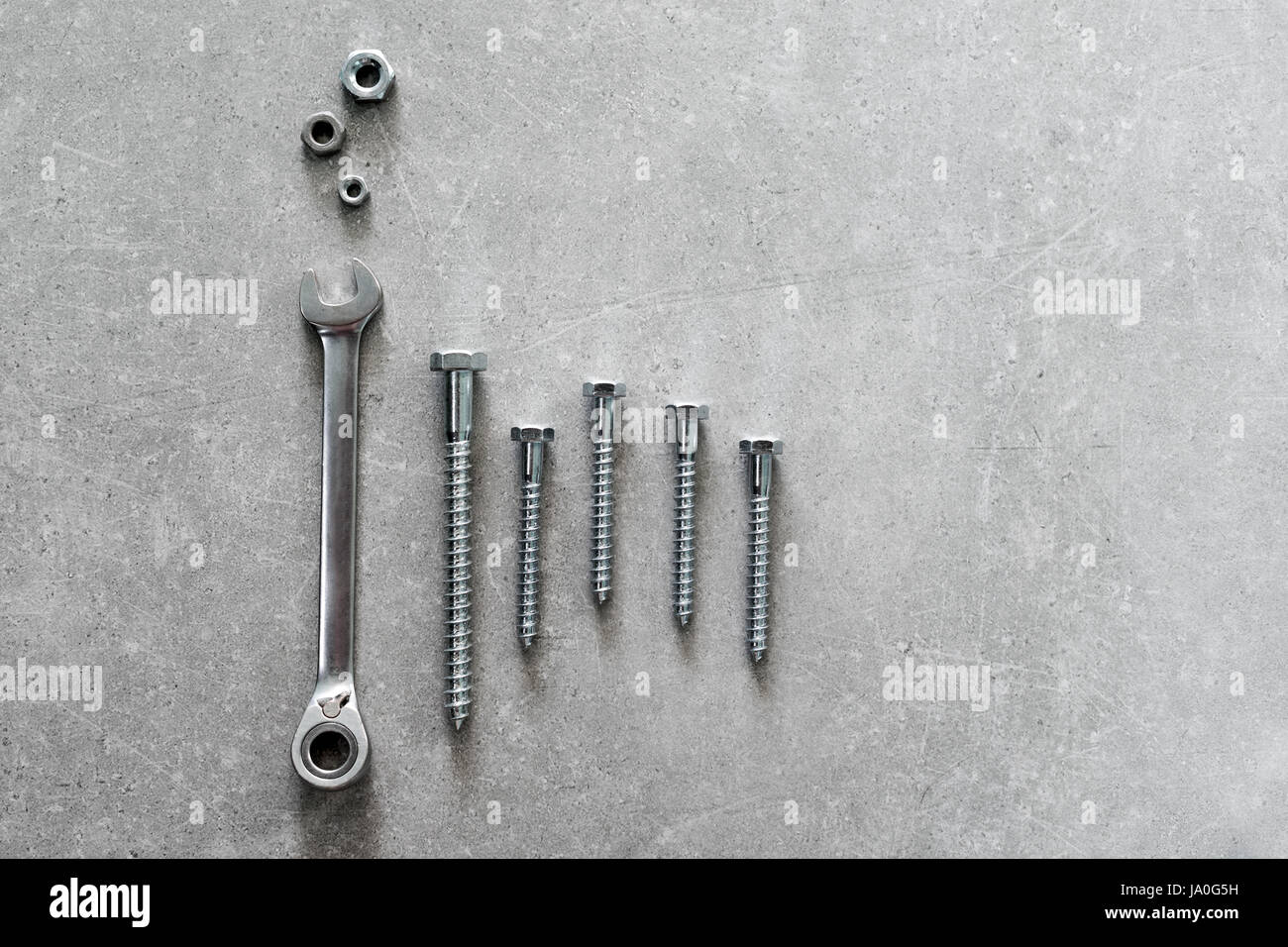 Construction tools. The screws, nuts and bolts on concrete background ...