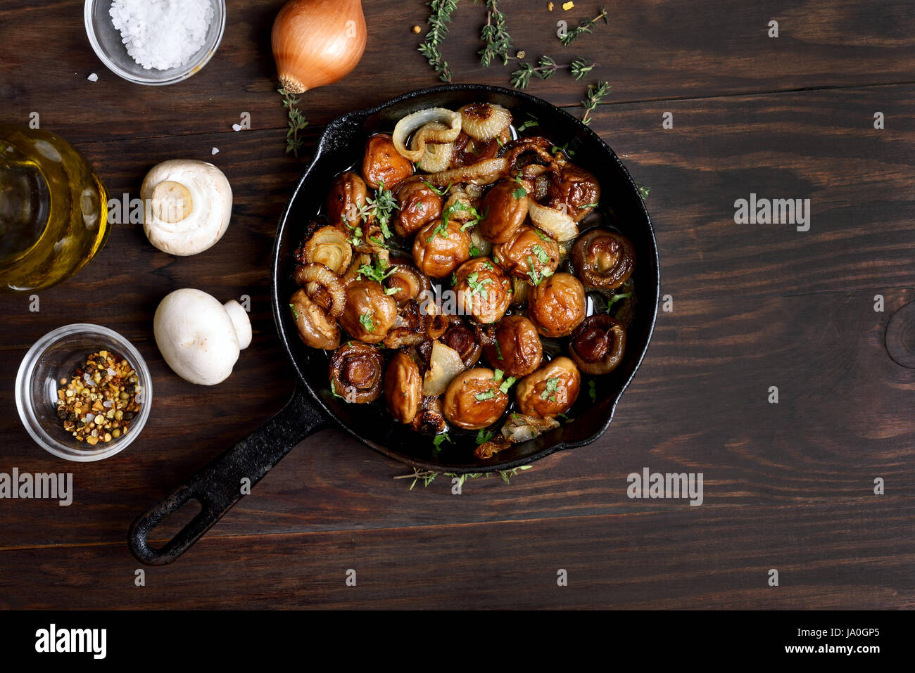 Delicious fried mushrooms in frying pan on wooden background with copy ...