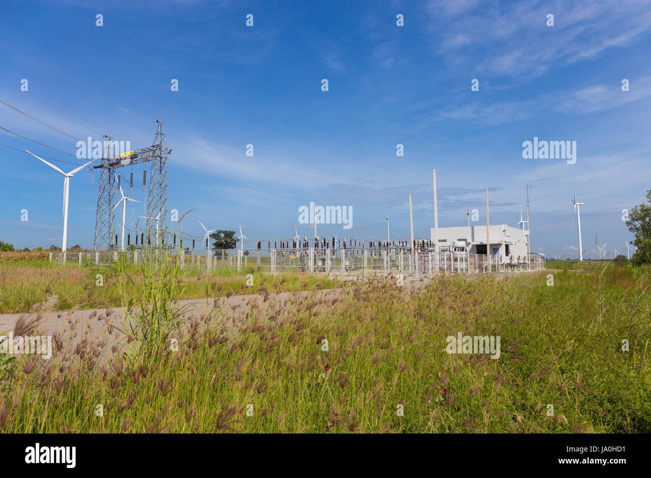 electricity pylons and power plant or station with wind turbine in ...