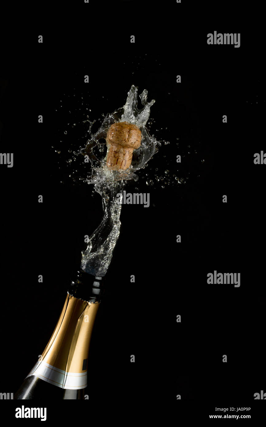 Champagne cork popping on black background Stock Photo - Alamy