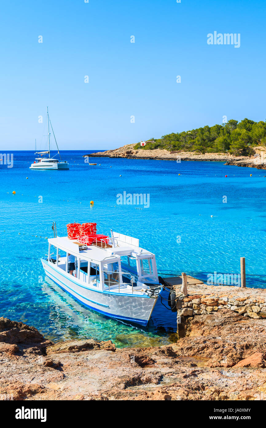 White and blue colour ferry boat for tourists mooring in Cala Portinatx ...