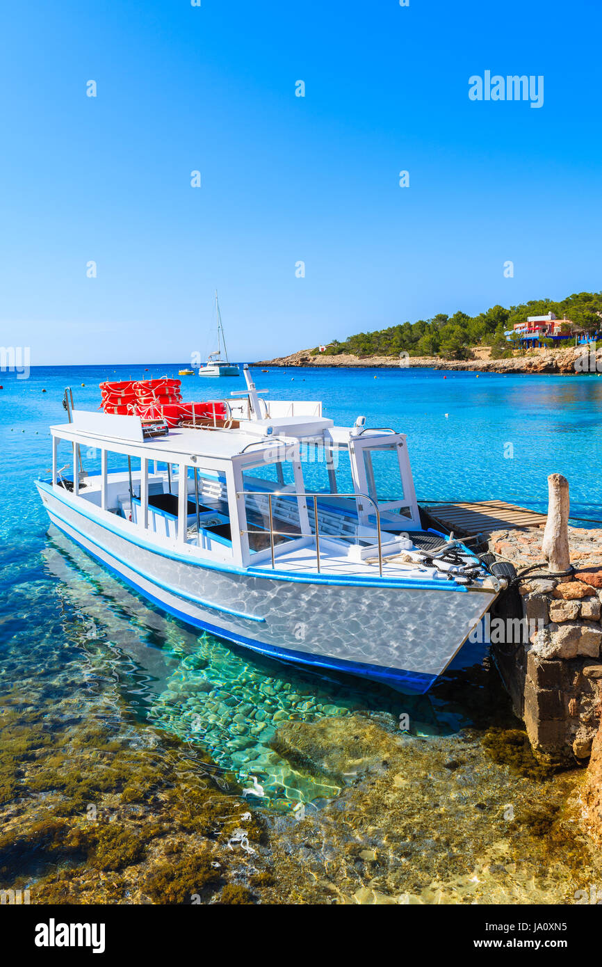 White and blue colour ferry boat for tourists mooring in Cala Portinatx ...
