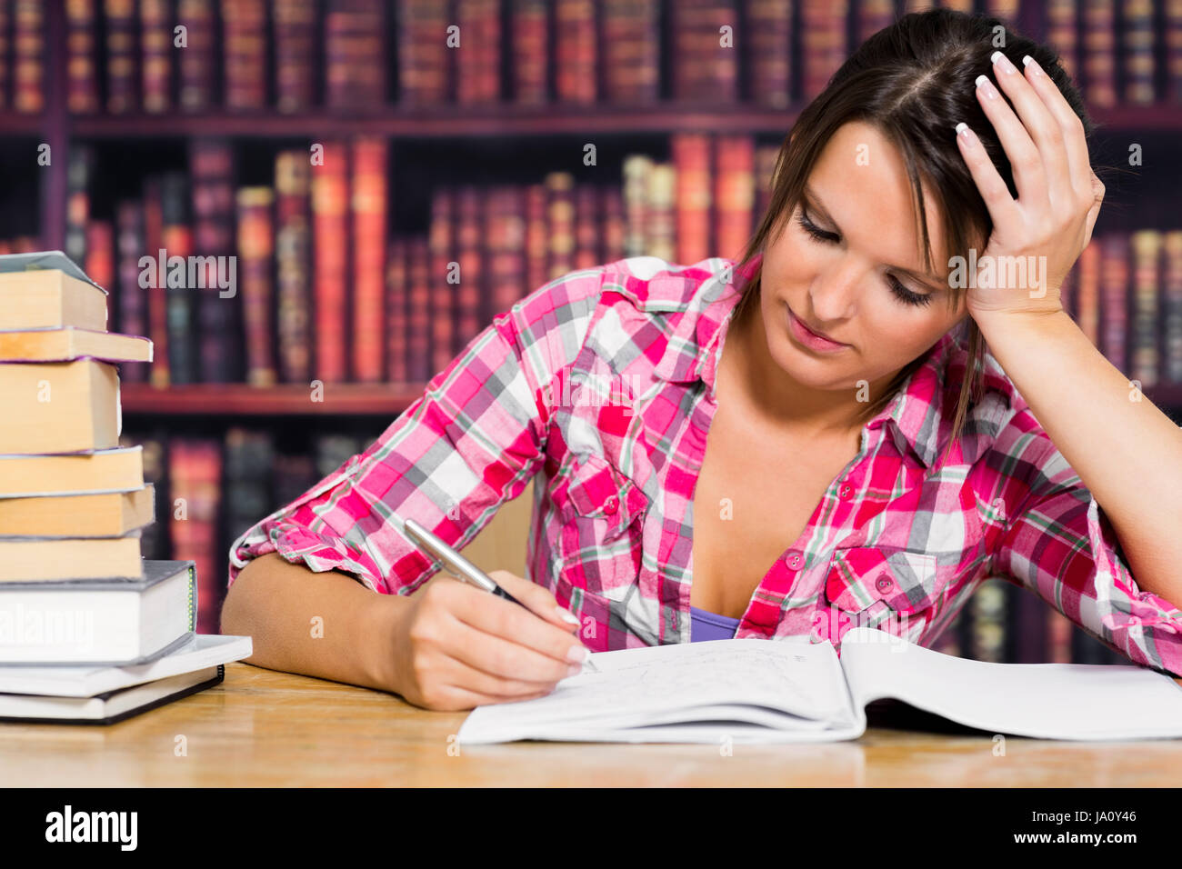 Female student working in college library Stock Photo - Alamy
