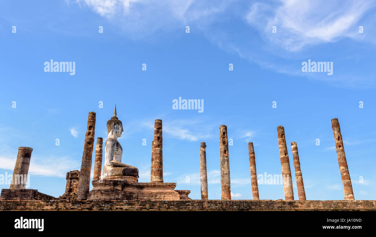 Ancient Buddha statue sitting posture among the ruins pillars under the ...