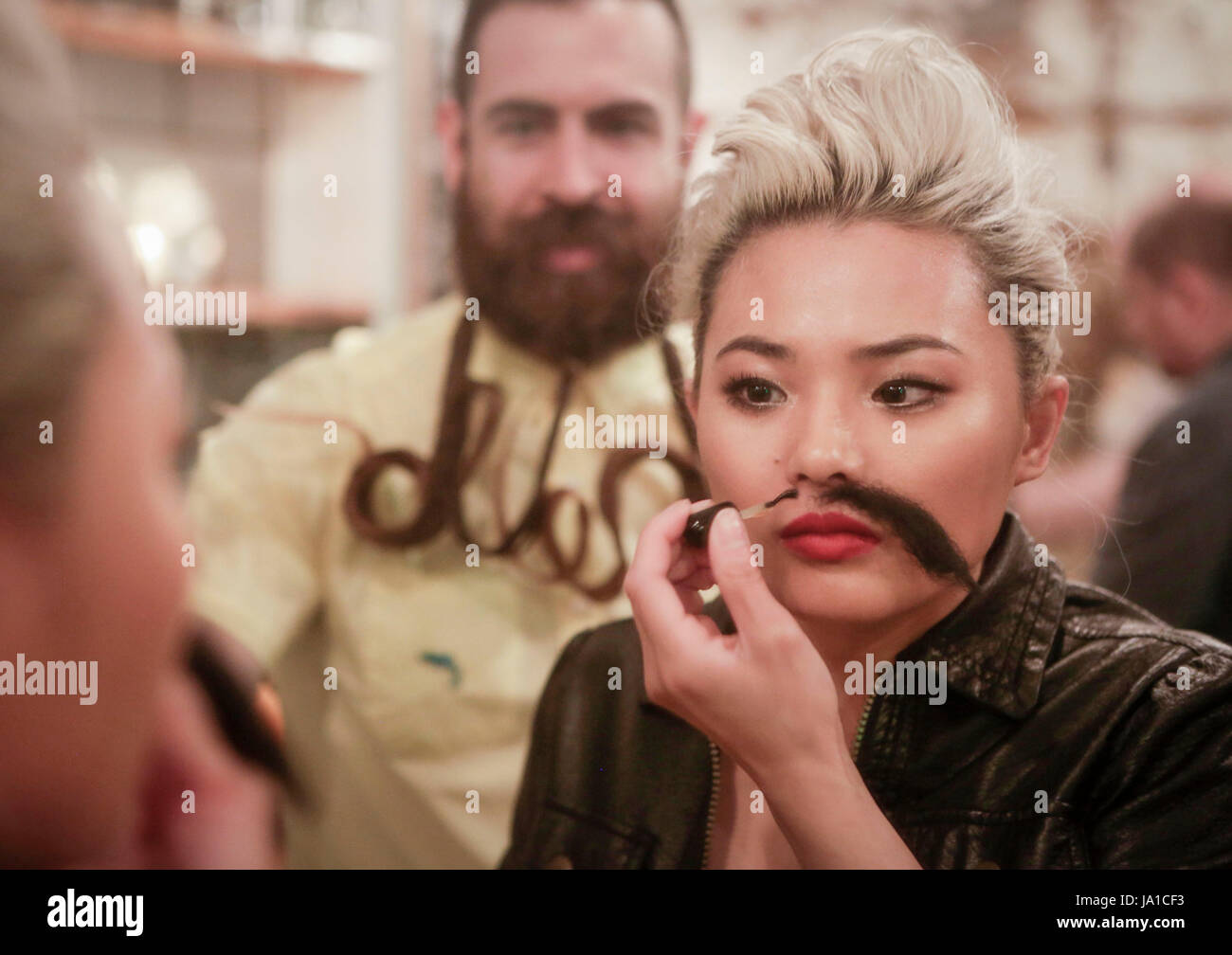 Vancouver, Canada. 3rd June, 2017. A woman sticks a fake moustache on ...