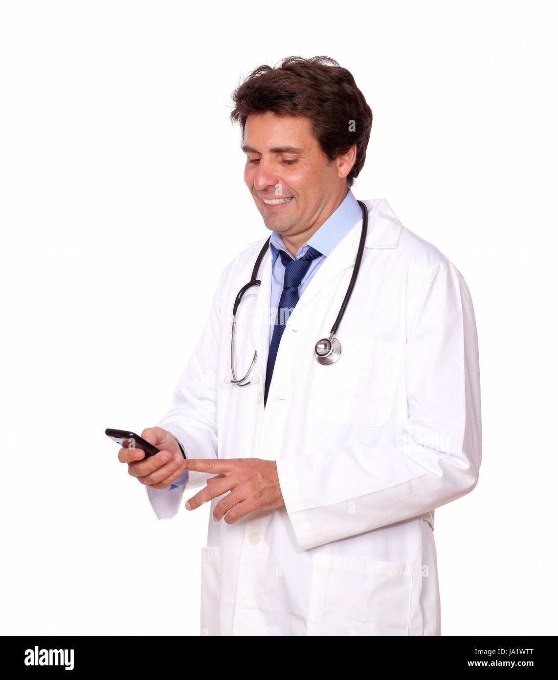Portrait of a medical doctor sending message by cellphone over white ...