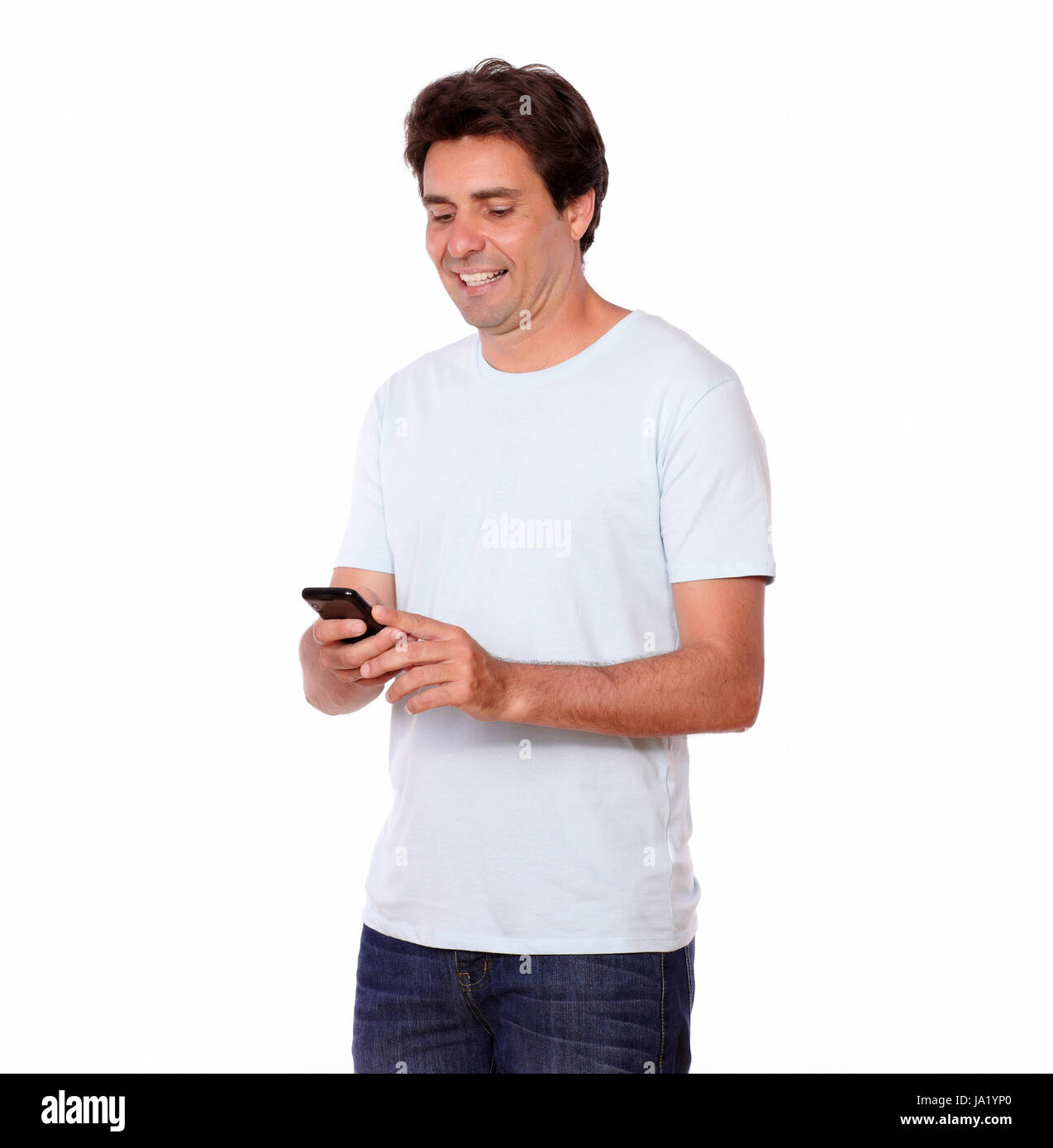Portrait of a charming guy sending a message on cellphone while ...