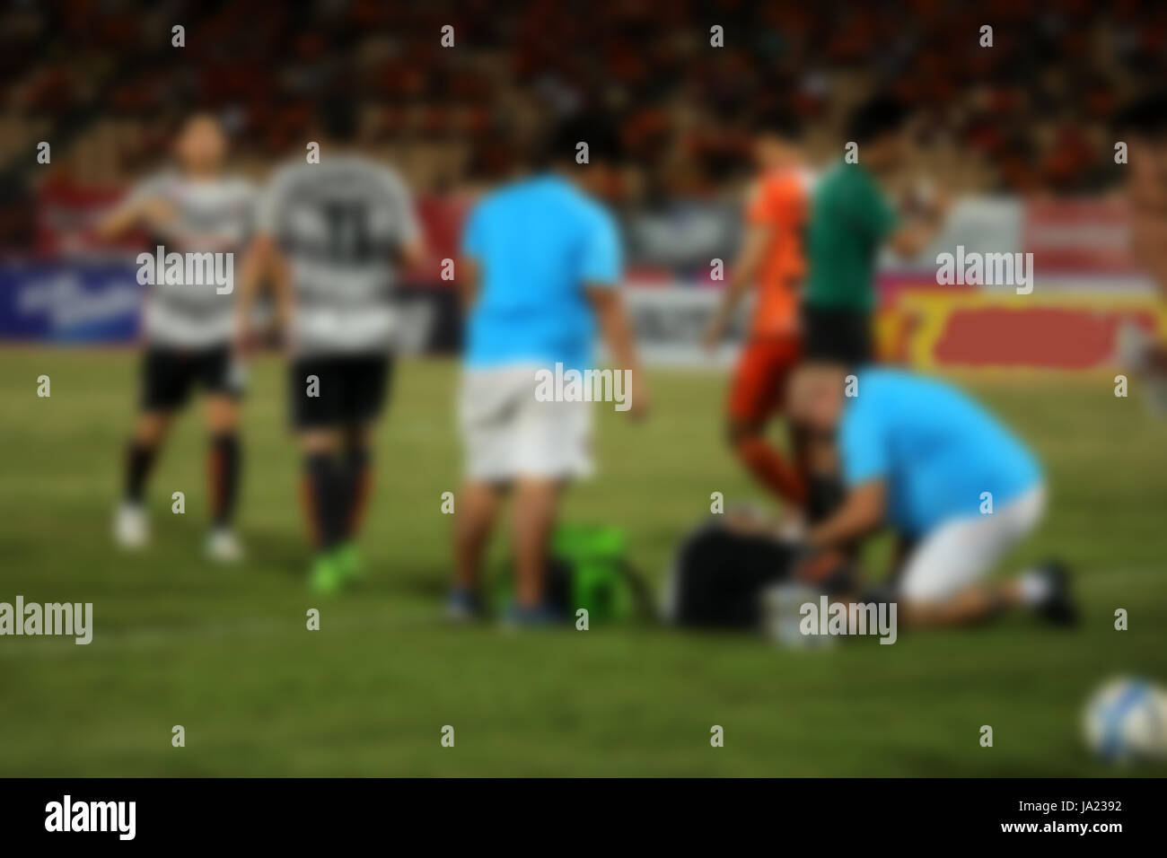 blurry Doctors and referee with injured player at the football match ...