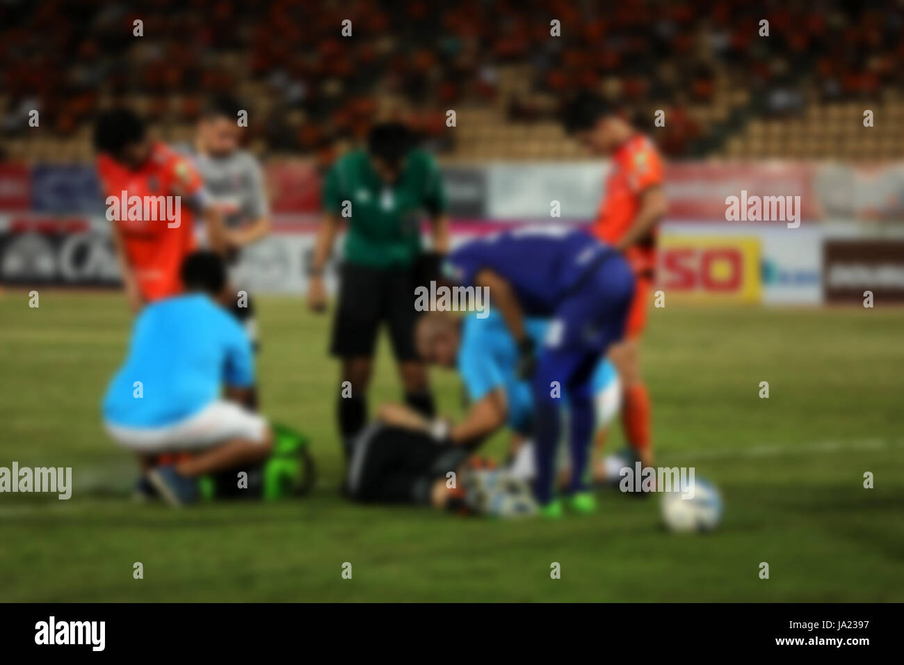 blurry Doctors and referee with injured player at the football match ...