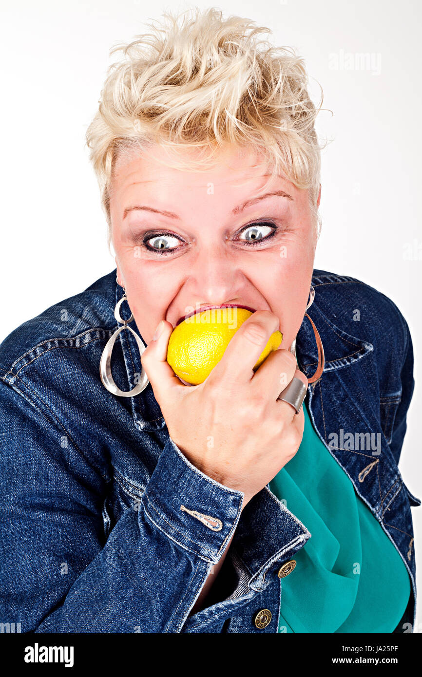 portrait of middelaged beautiful woman eating fresh lemon Stock Photo ...