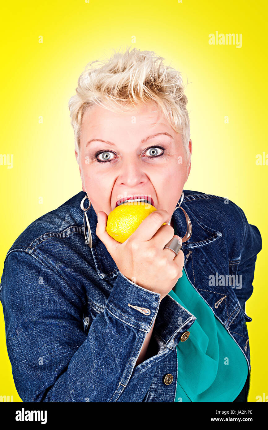 portrait of middelaged beautiful woman eating fresh lemon Stock Photo ...