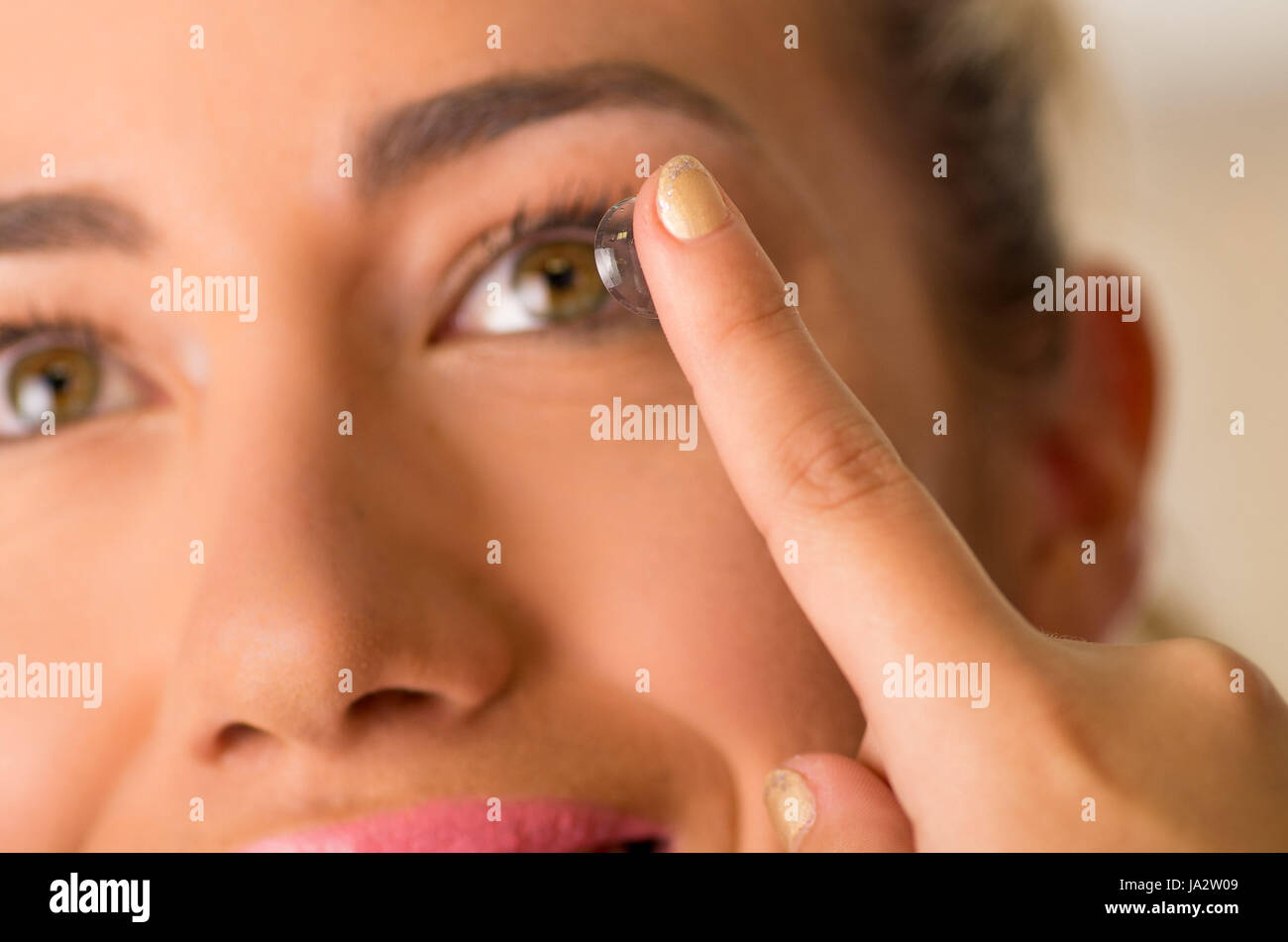 Young woman putting contact lens in her eye close up Stock Photo - Alamy