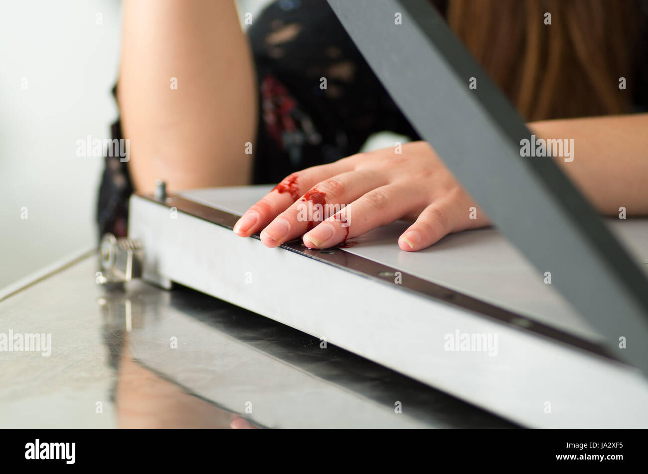 Beautiful young woman using a paper cutter cutting paper Stock Photo ...