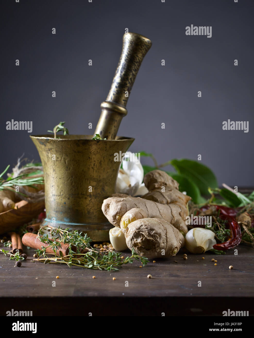 Different herbs and spices on a wooden table . Old copper mortar with ...