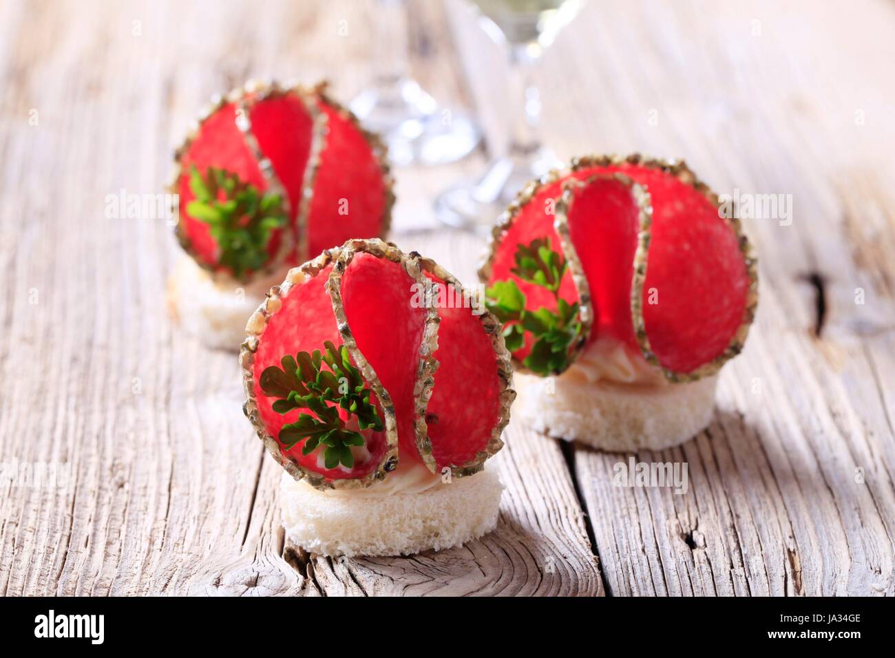 Bite-sized appetizers - Slices of spicy salami on bread Stock Photo - Alamy