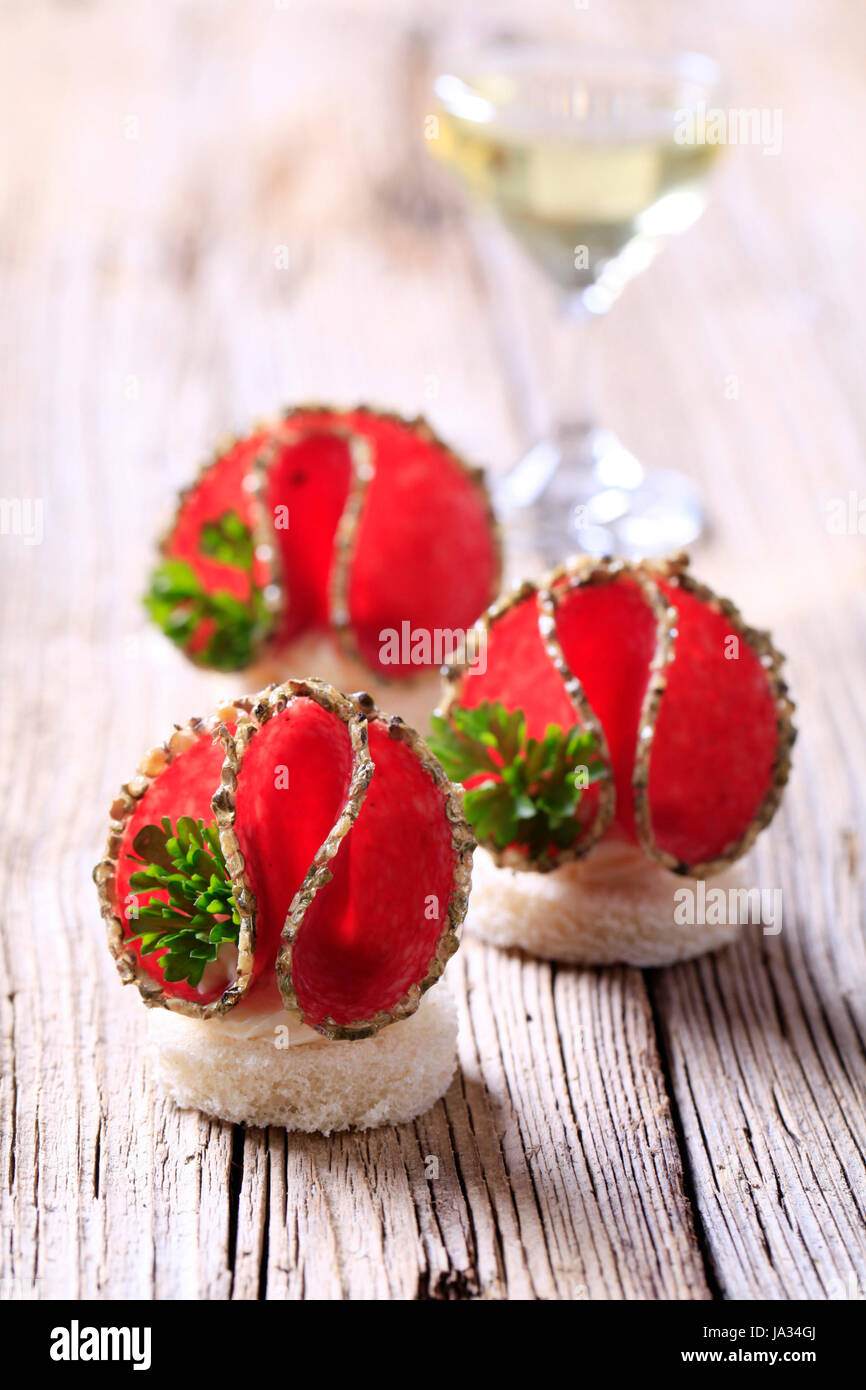 Bite-sized appetizers - Slices of spicy salami on bread Stock Photo - Alamy