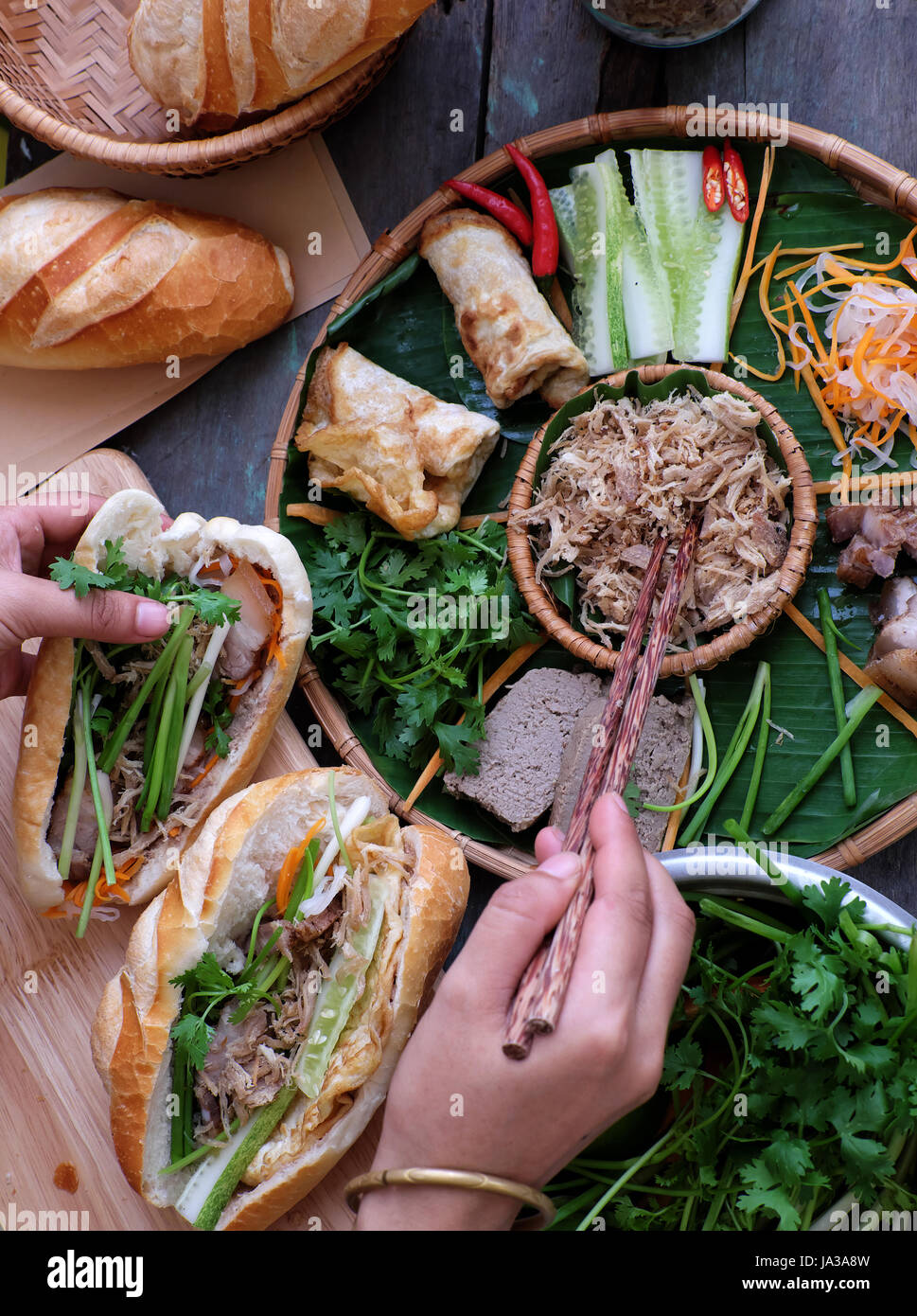 Woman hand make banh mi thit or Vietnamese bread, famous street food ...