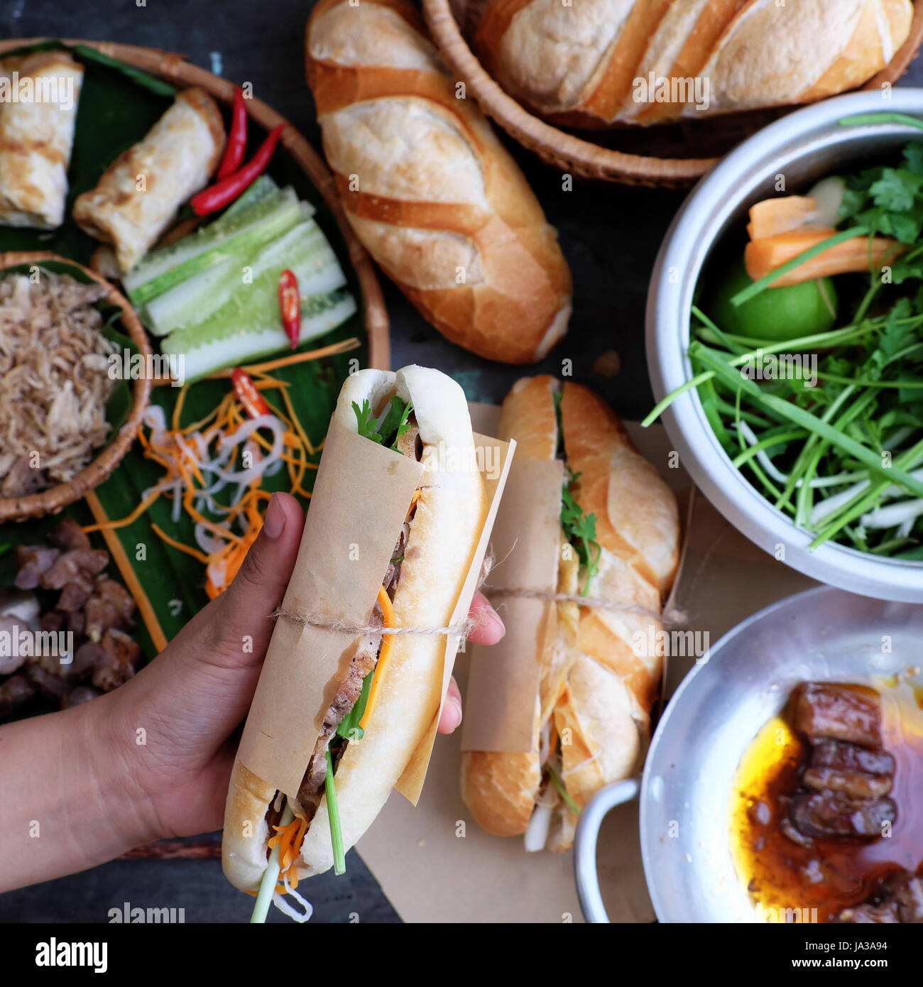 Woman hand make banh mi thit or Vietnamese bread, famous street food ...