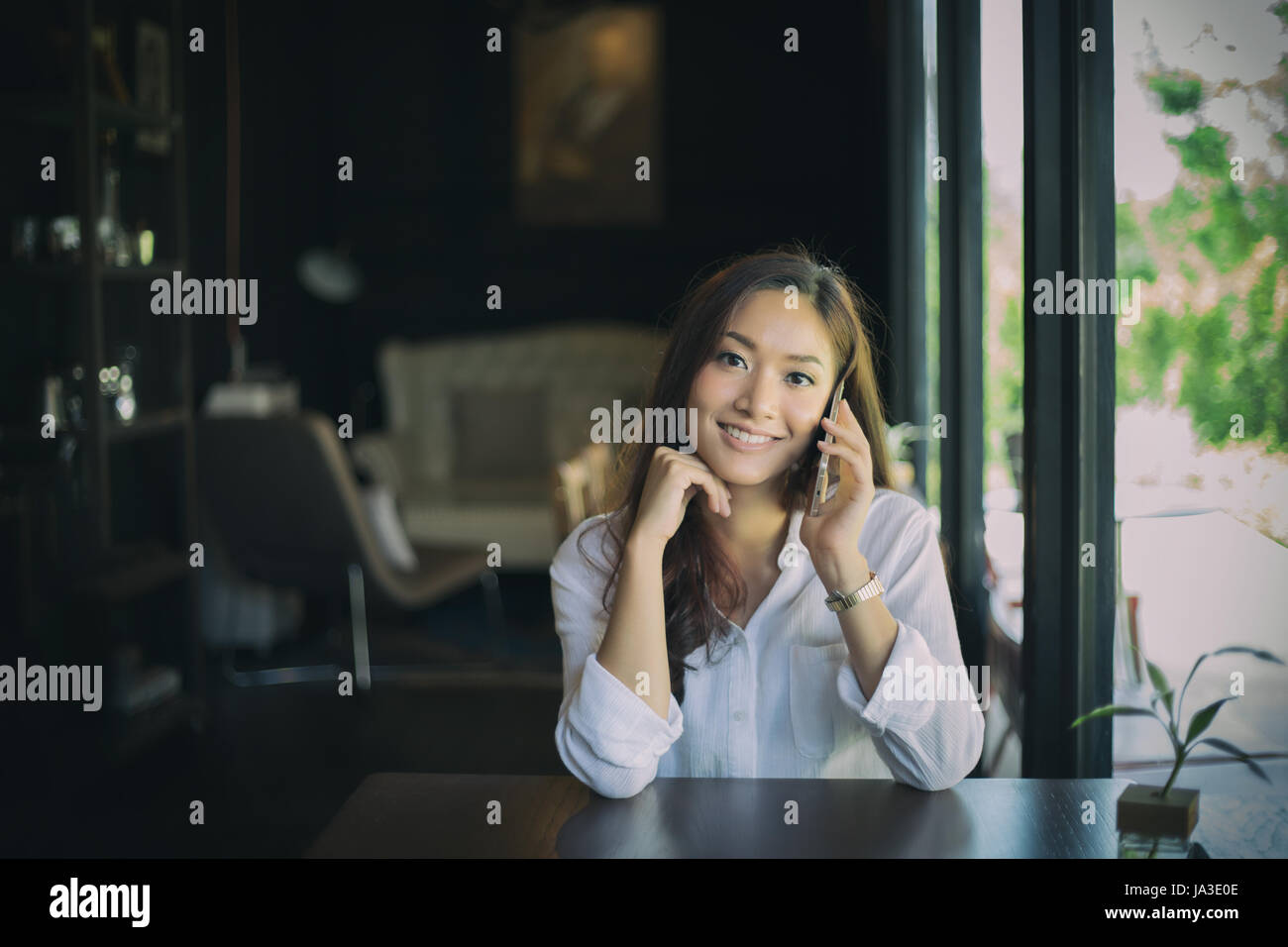 woman asian calling with cell telephone while sitting alone in coffee ...