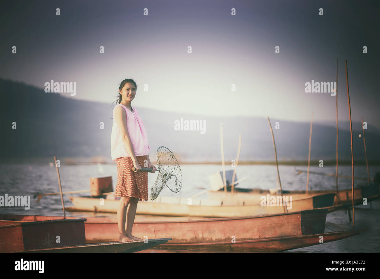 Asian women fisherman is driving a boat to catch fish Stock Photo - Alamy