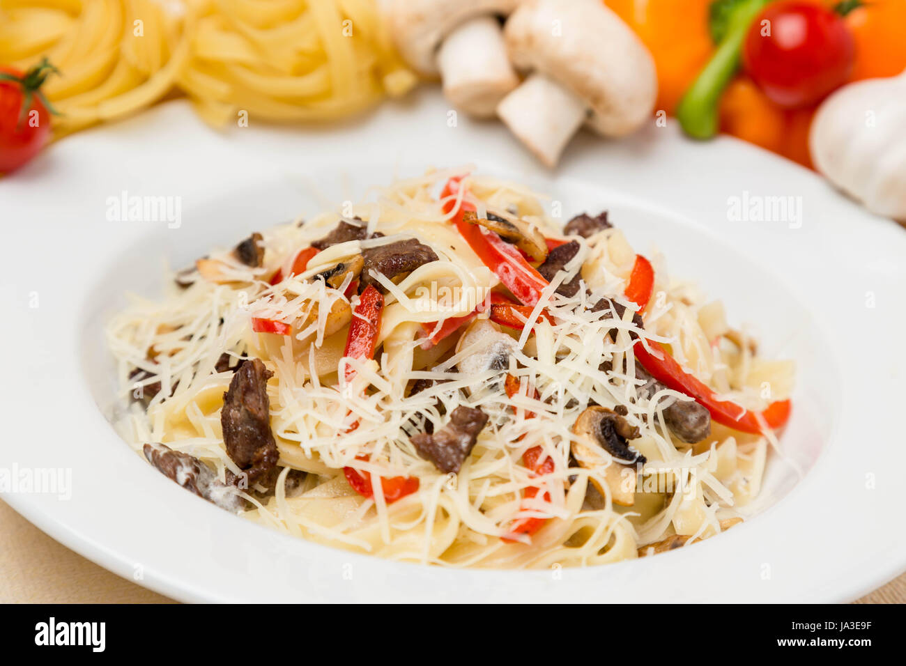 hot pasta with garnish on white plate Stock Photo - Alamy