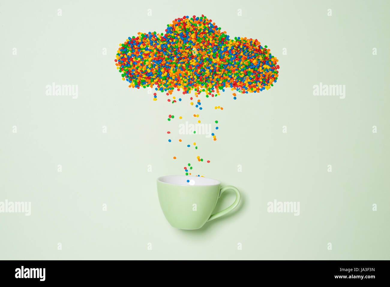 Candies in shape of rainy cloud on green background. Weather concept ...
