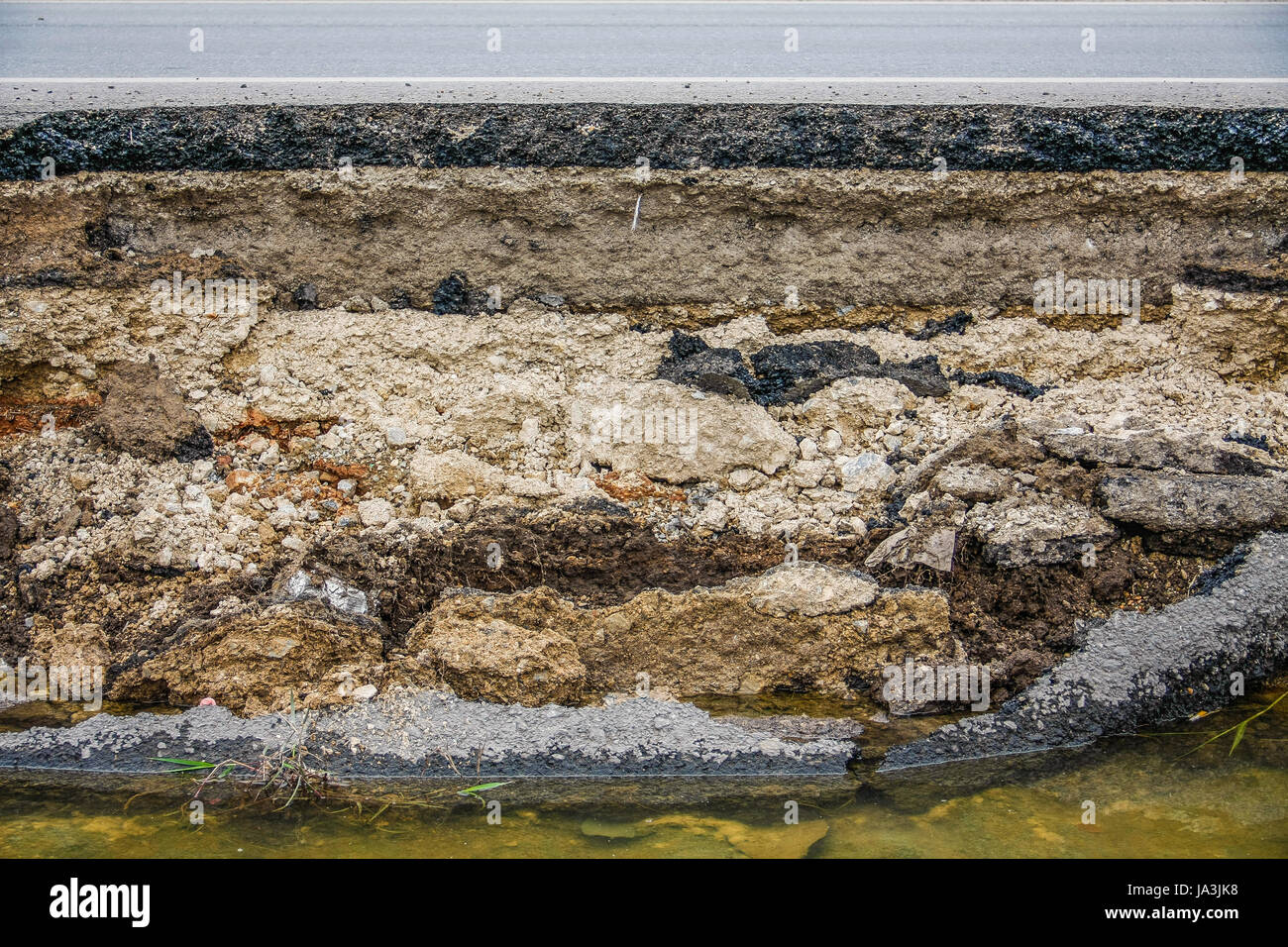 broken asphalt layer road with water Stock Photo - Alamy