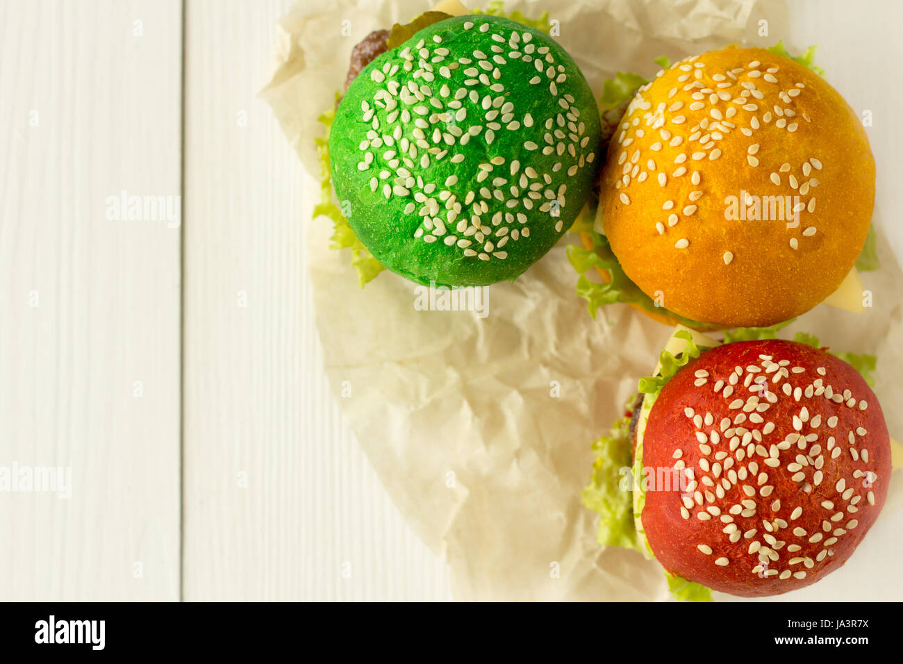 Multi colored burgers on cooking paper top view selective focus Stock ...