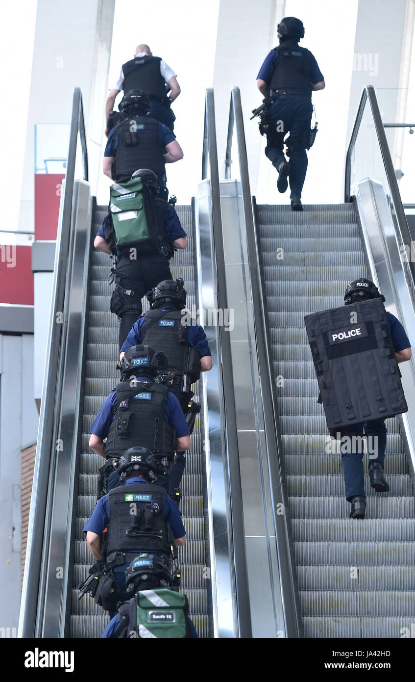 Armed police on an escalator at the foot of the Shard outside London ...