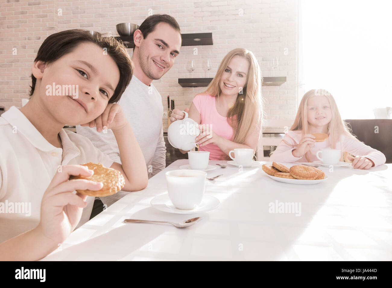 Happy family with children having breakfast at home Stock Photo - Alamy