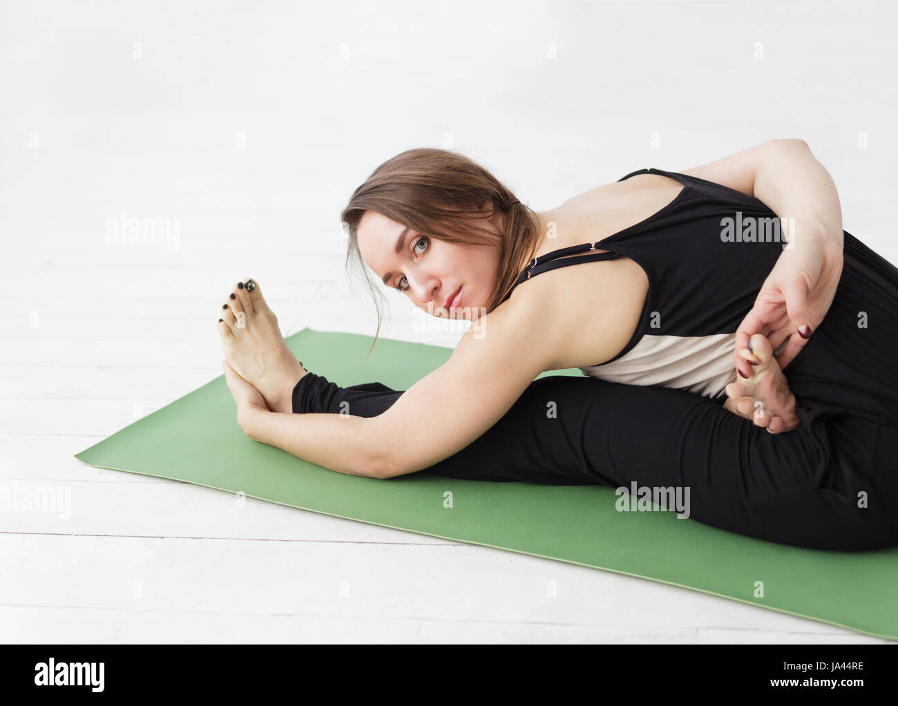 Seated forward bend. Intense dorsal stretch girl is doing yoga while ...