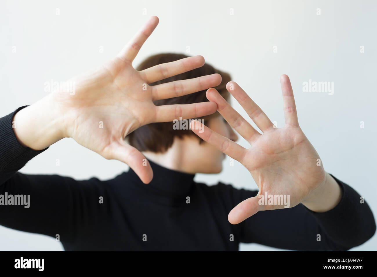 Girl turns aside, stretching her hands forward. Pushing someone away ...