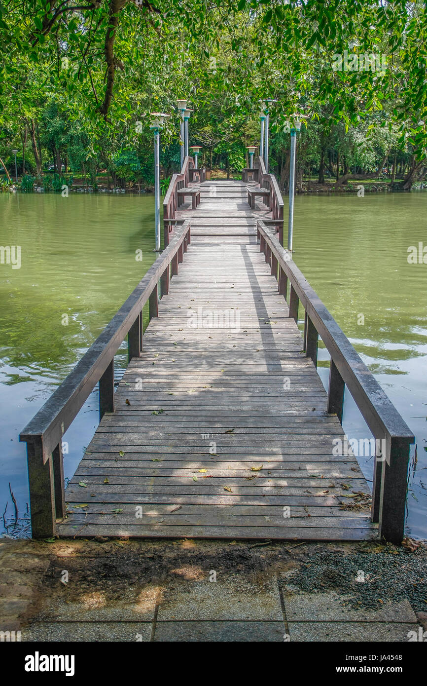 walkway wooden bridge over pond on park of silpakorn university ...