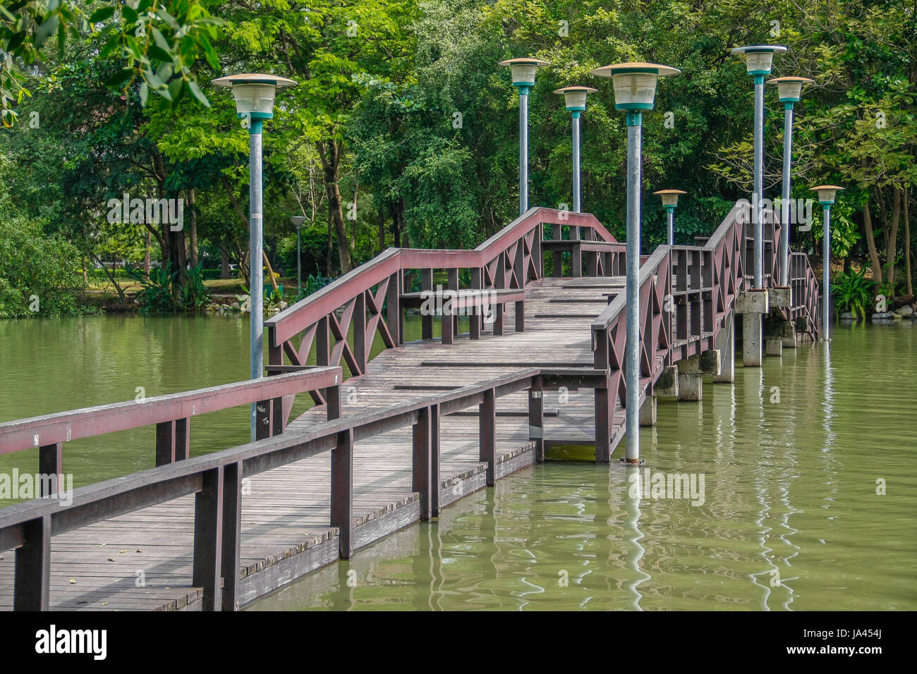 walkway wooden bridge over pond on park of silpakorn university ...