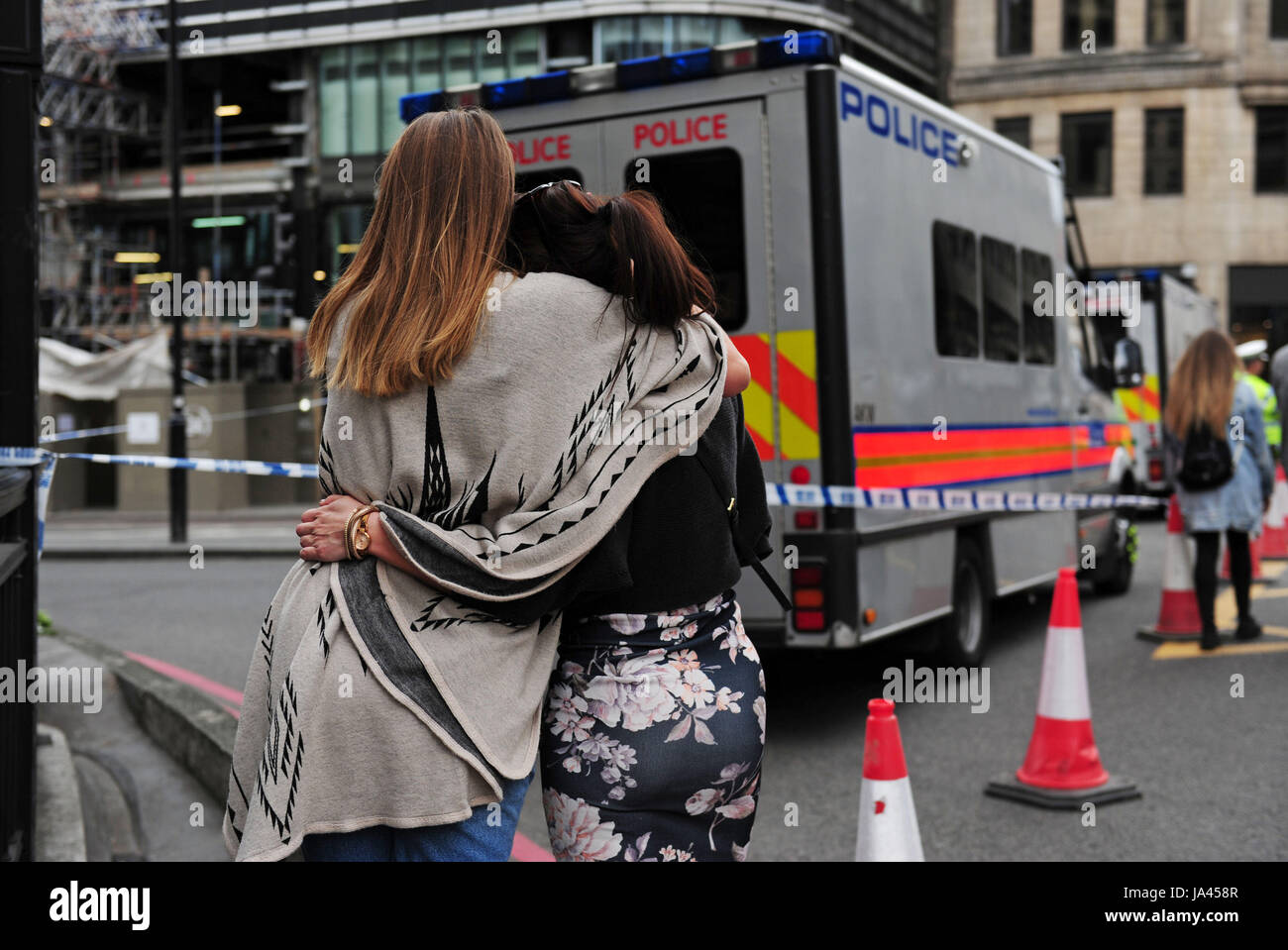 Two women hug after bringing flowers to add to tributes laid on the ...