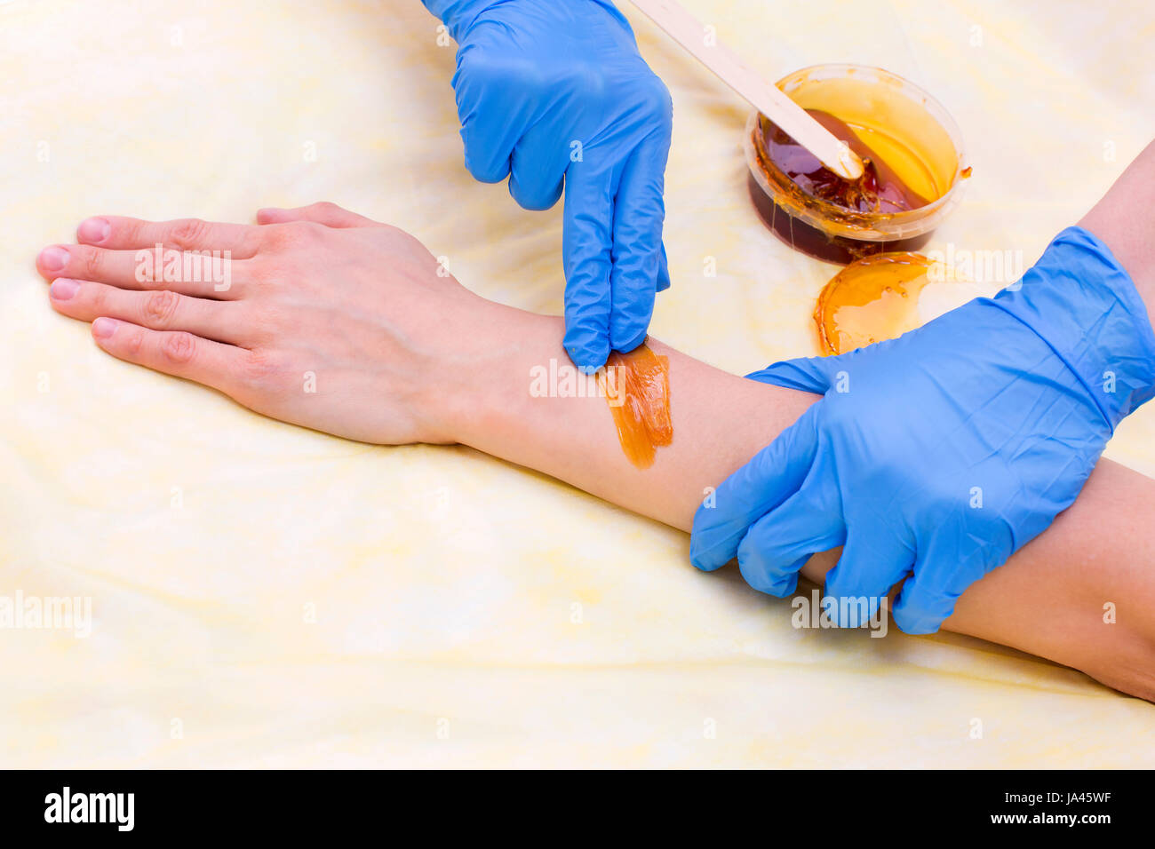 Depilation sugar processes woman passes in a beauty salon Stock Photo ...