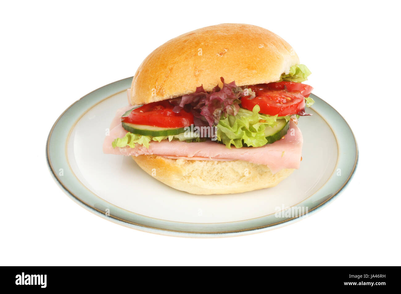 Ham and salad in a crusty roll on a plate isolated against white Stock ...
