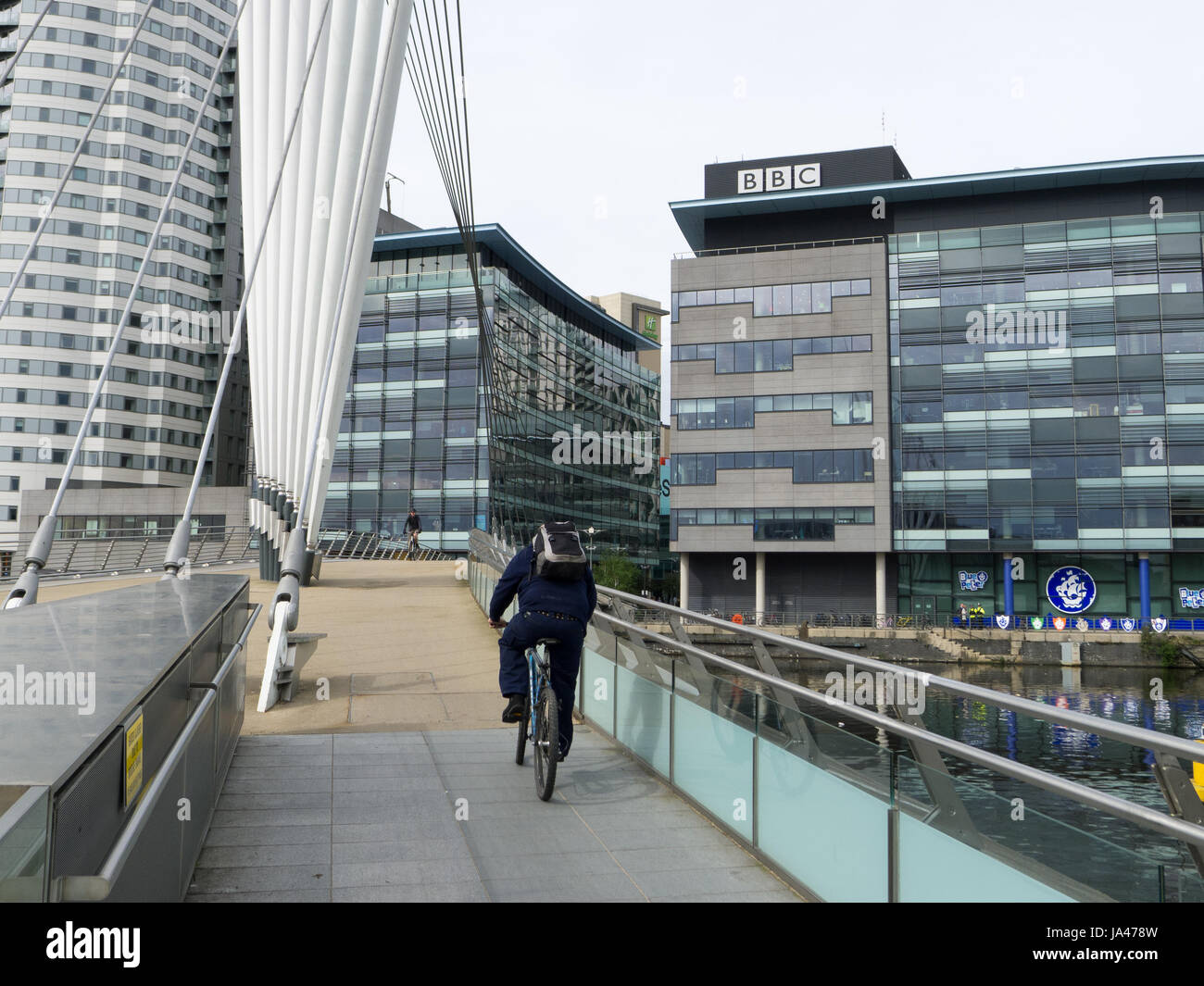 Cyclist crossing bridge at Media City, Salford Quays, Manchester Stock ...