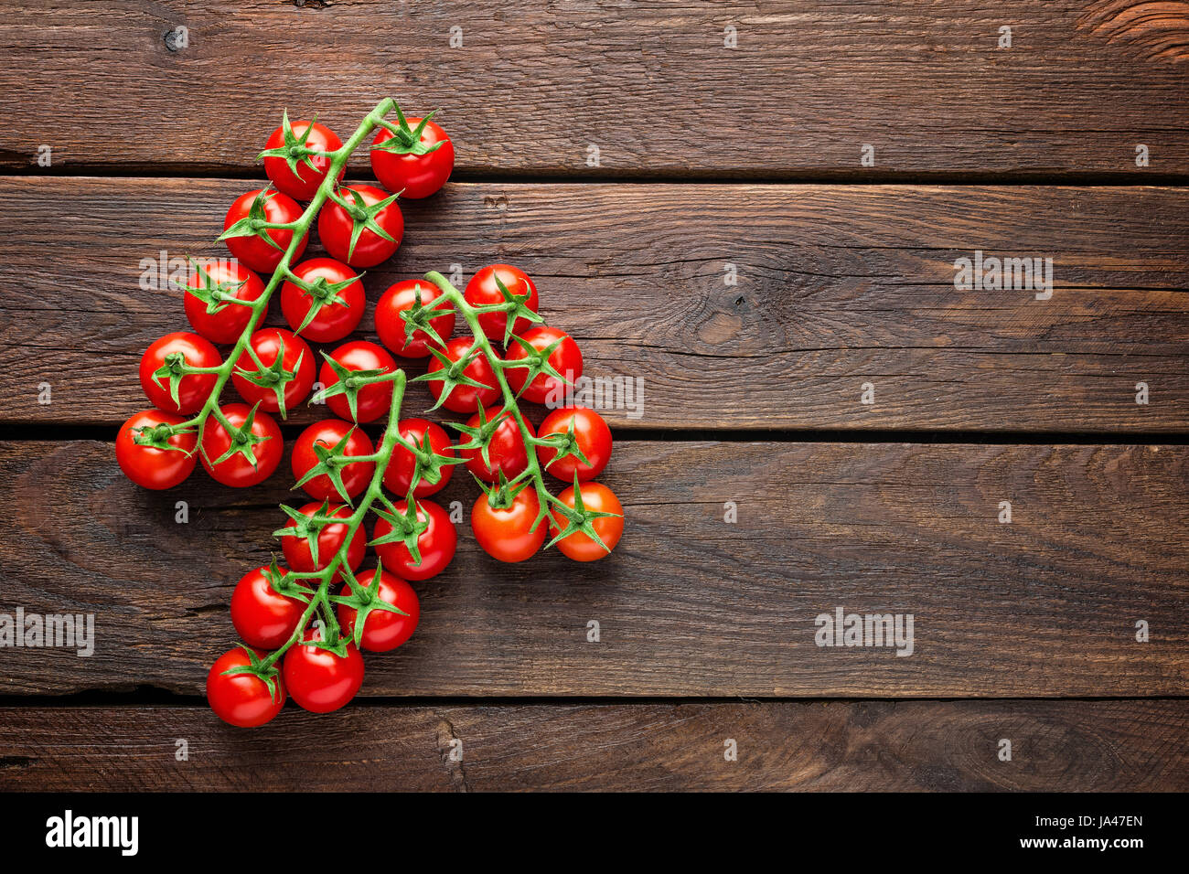 Fresh cherry tomatoes on twigs on wooden table, top view Stock Photo ...