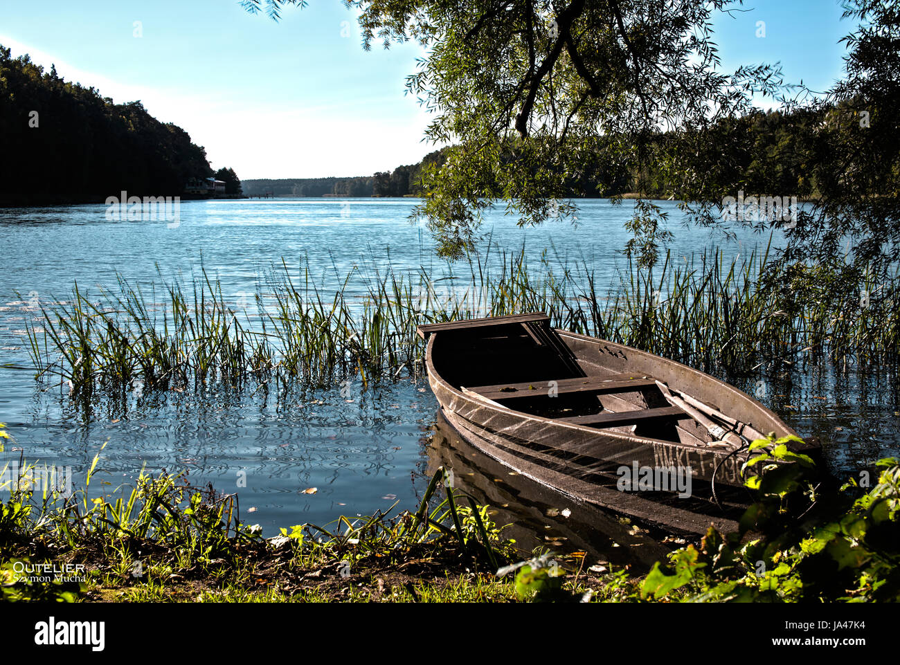 An summer view to a polish lake with a fishing boot. Colorful leaves ...