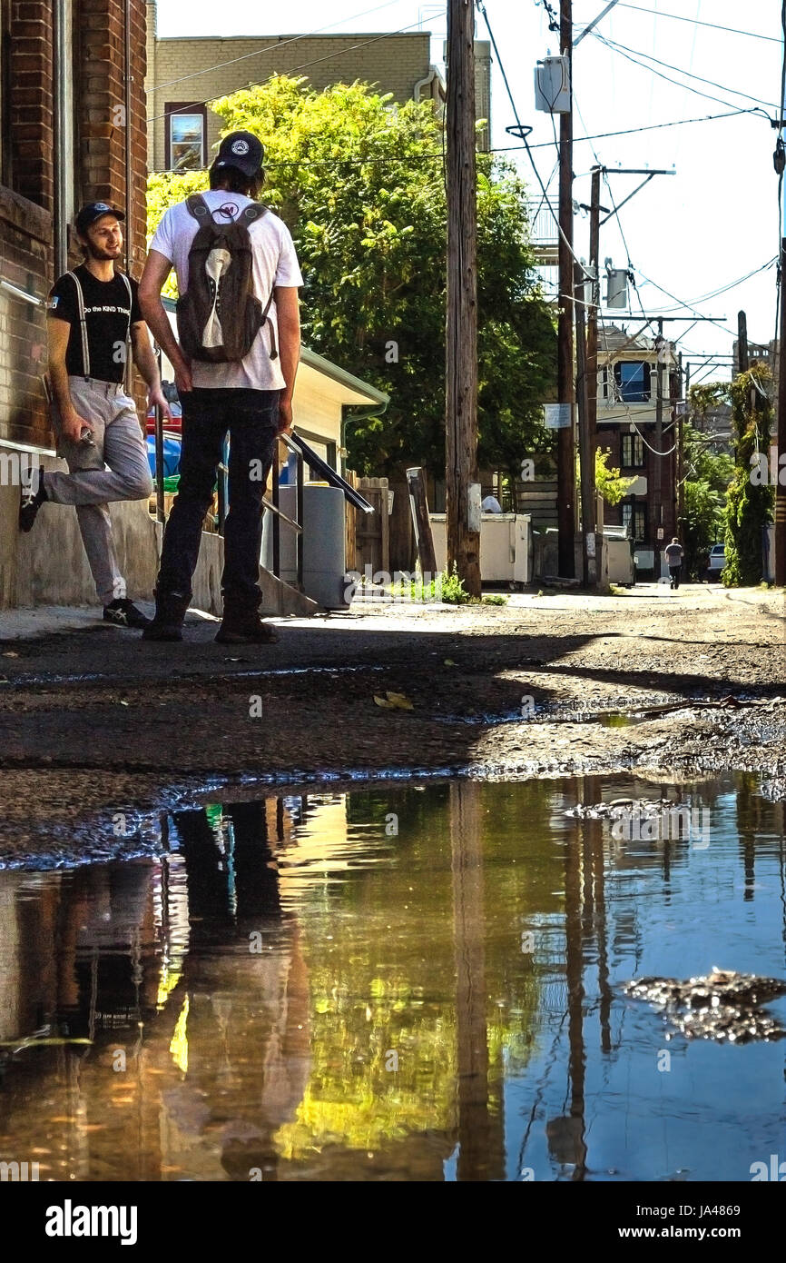 Two hipsters having a conversation on back alley in Lodo Denver Stock ...
