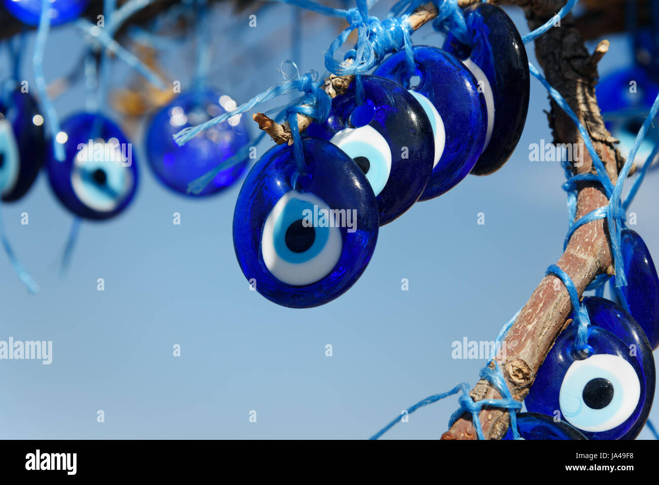 Nazars, Turkish Evil eye charms on the branches of tree on blue sky ...