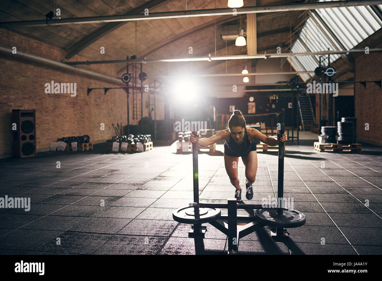 Sportive woman pushing bogie in gym. Horizontal indoors shot Stock ...