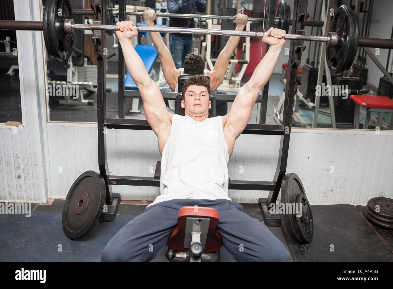 Muscular guy exercising in the gym. Lifting heavy weights in the gym ...