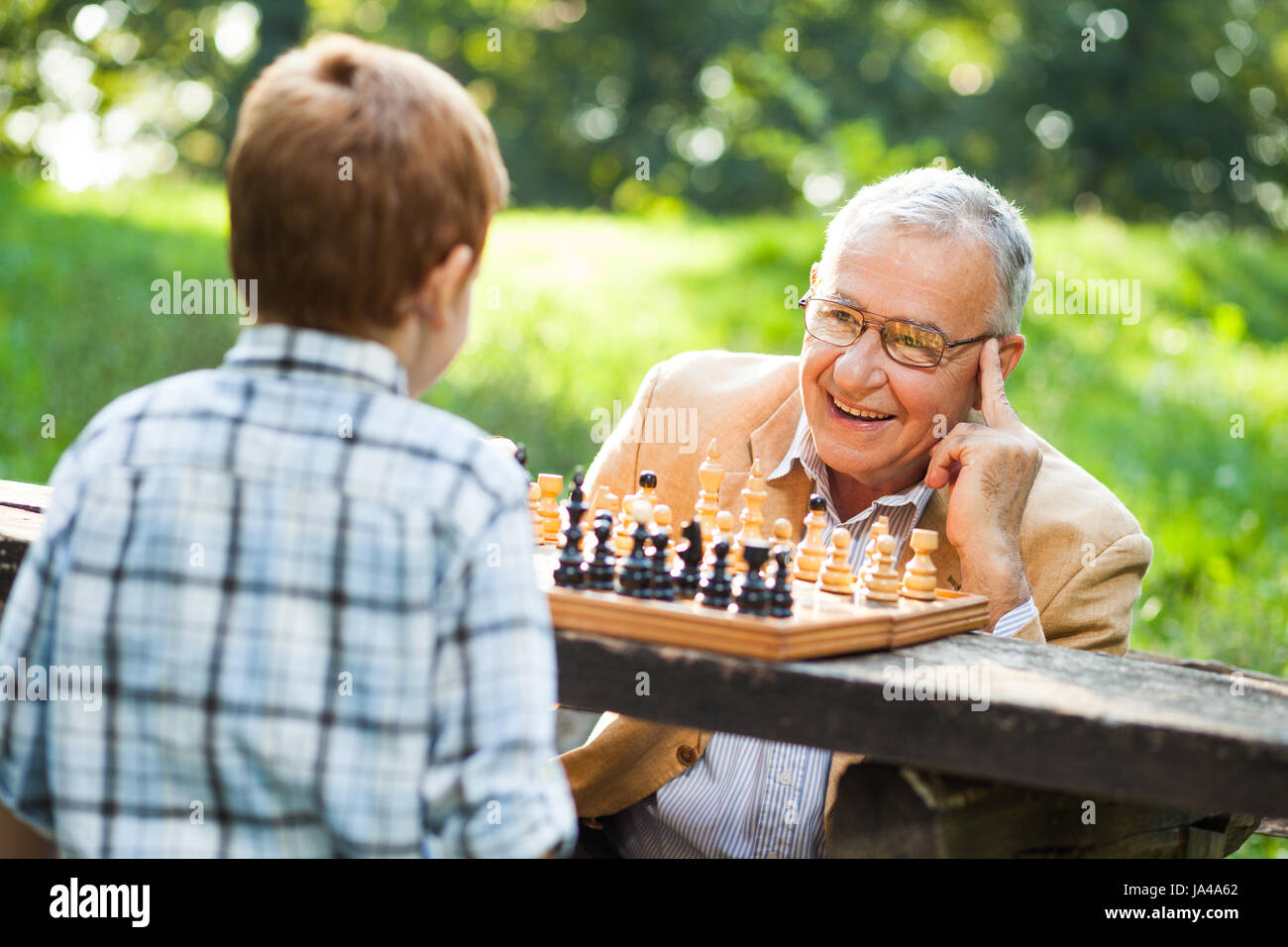 Grandfather and grandson are playing chess in park Stock Photo - Alamy